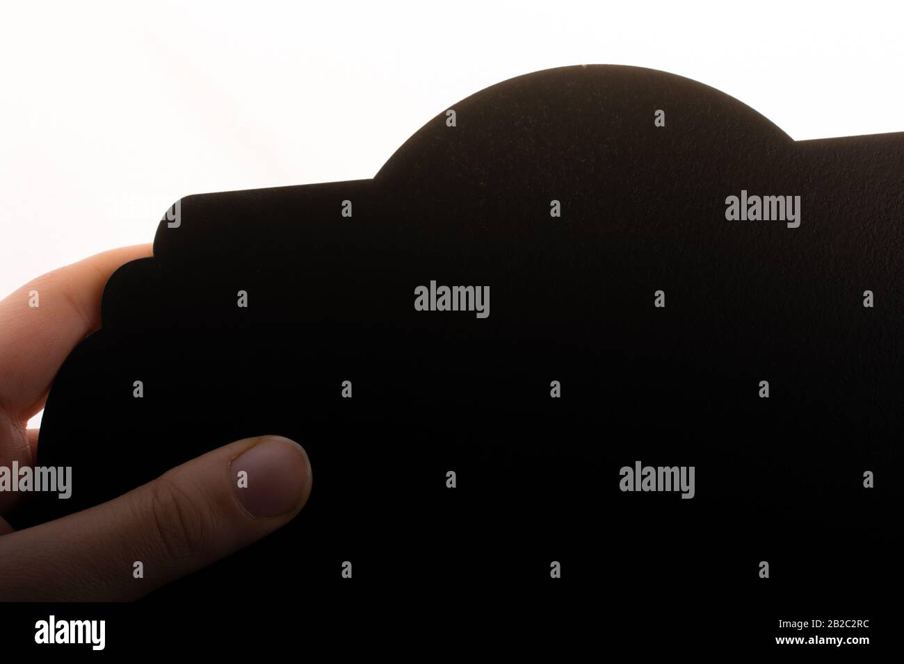 Black speech bubble shaped notice board in hand on white background ...
