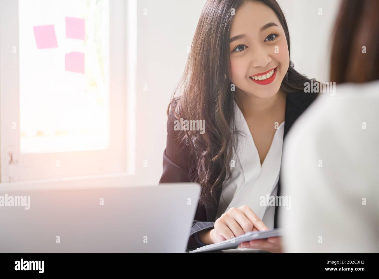 A young attractive asian woman is interviewing for a job. Her ...