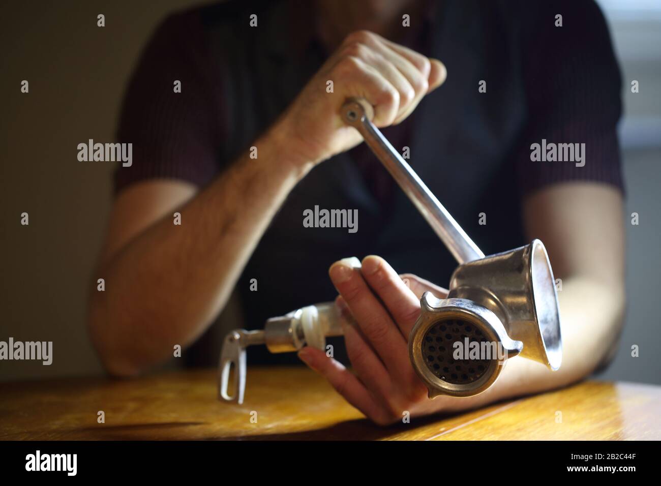 A man twists a meat grinder Stock Photo - Alamy