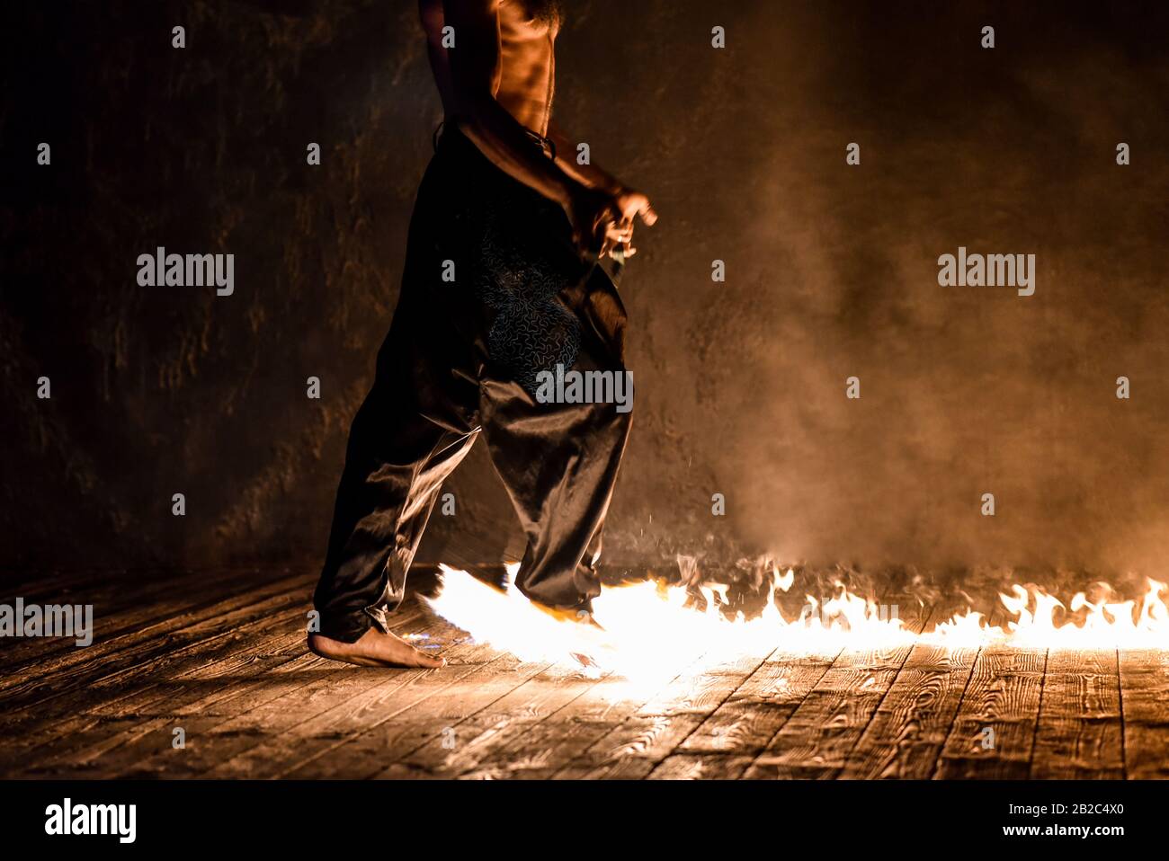 Fakir juggles fire on a black background Stock Photo - Alamy