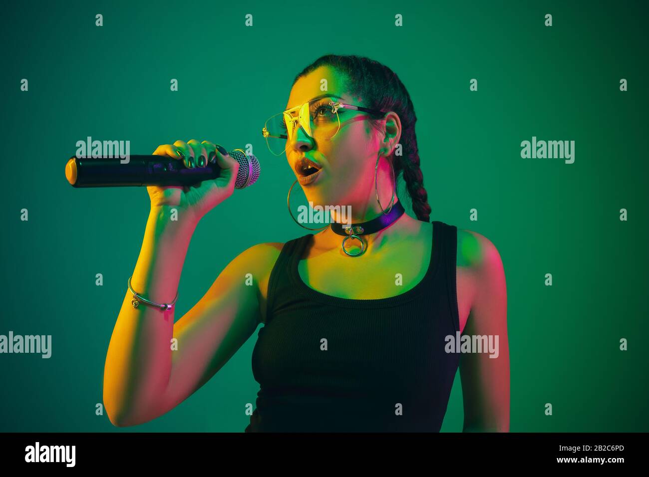 Caucasian female singer portrait isolated on green studio background in ...