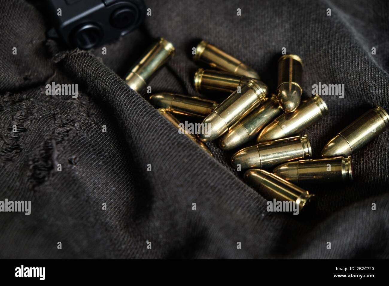 9mm semi autometic hand gun with FMJ bullet on fabric, Crime concept ...