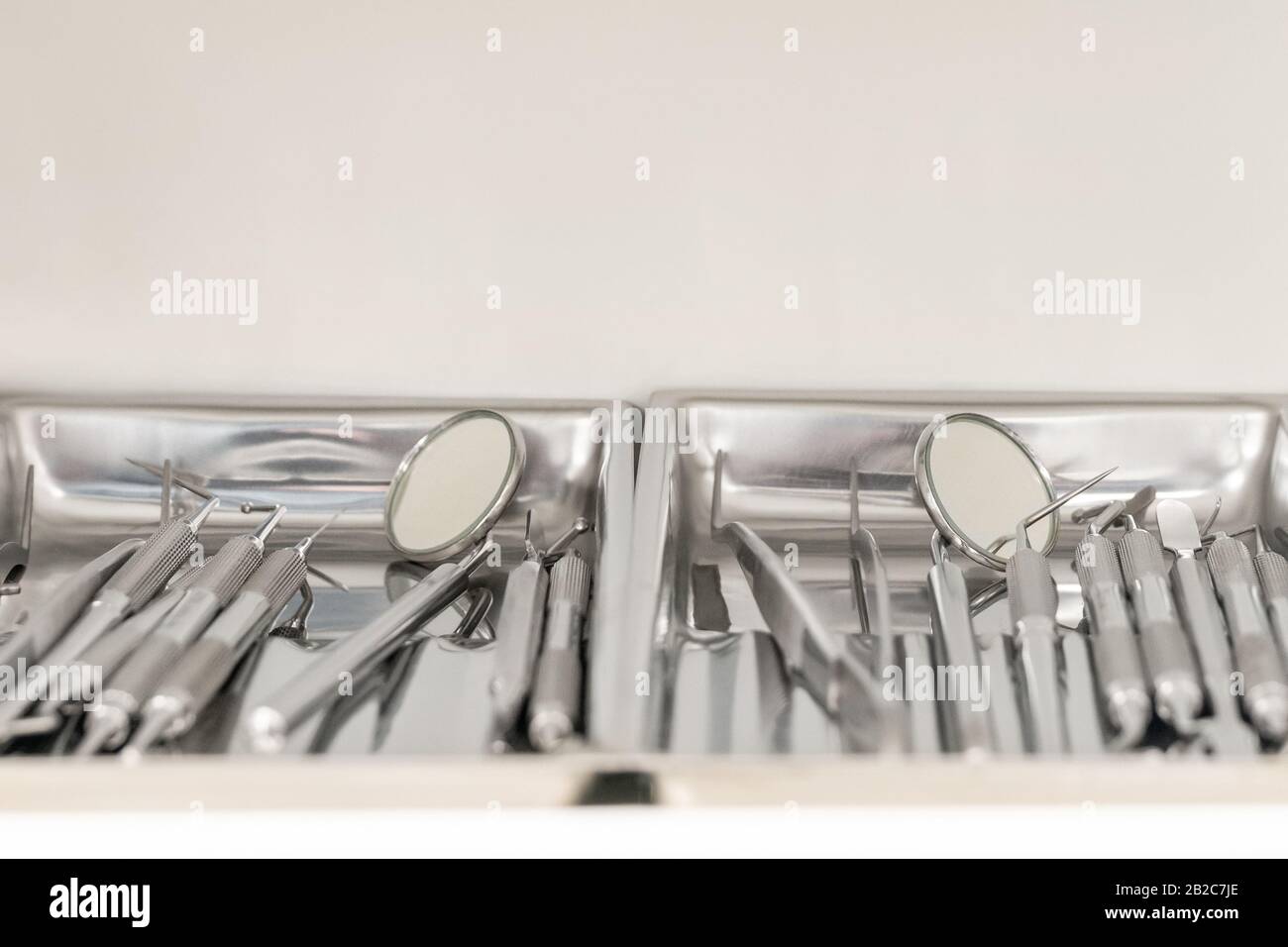 several sets of dental instruments in trays lying next to each other ...