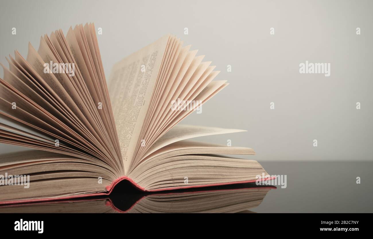 Close up beautiful open book on a gray and glass table background Stock ...