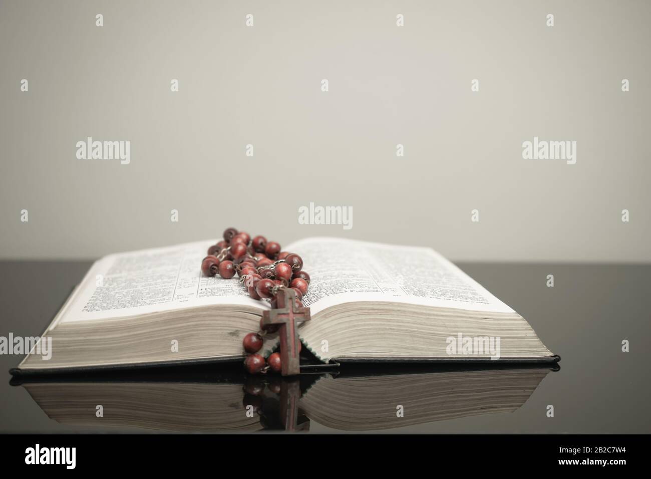 Open Holy Bible on a glass table and white background. Religion concept ...