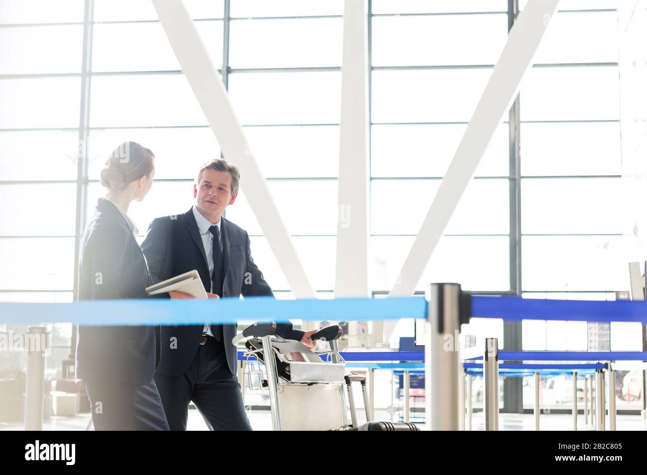 Mature businessman talking with his business partner in check in are at ...