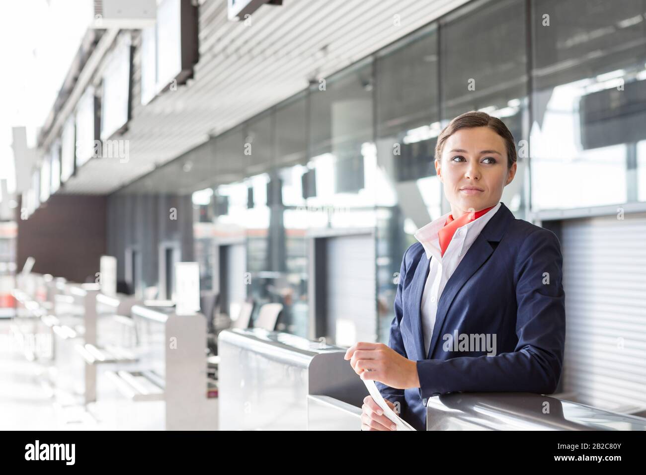 Portrait of young attractive passenger service agent holding boarding ...