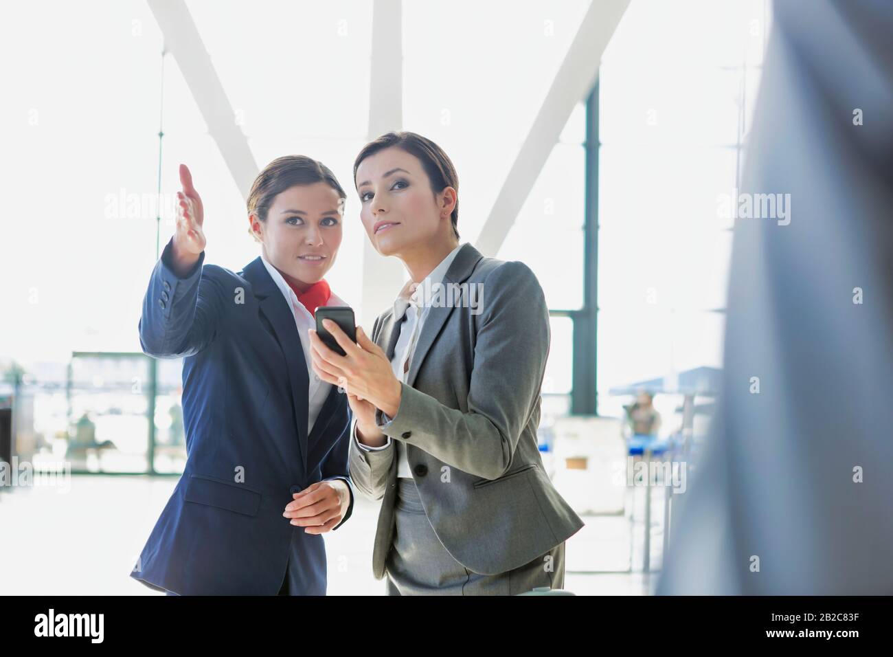 Passenger service agent assisting and giving directions with ...