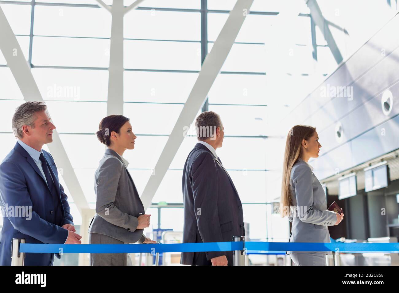 Business people queueing for check in at airport Stock Photo - Alamy
