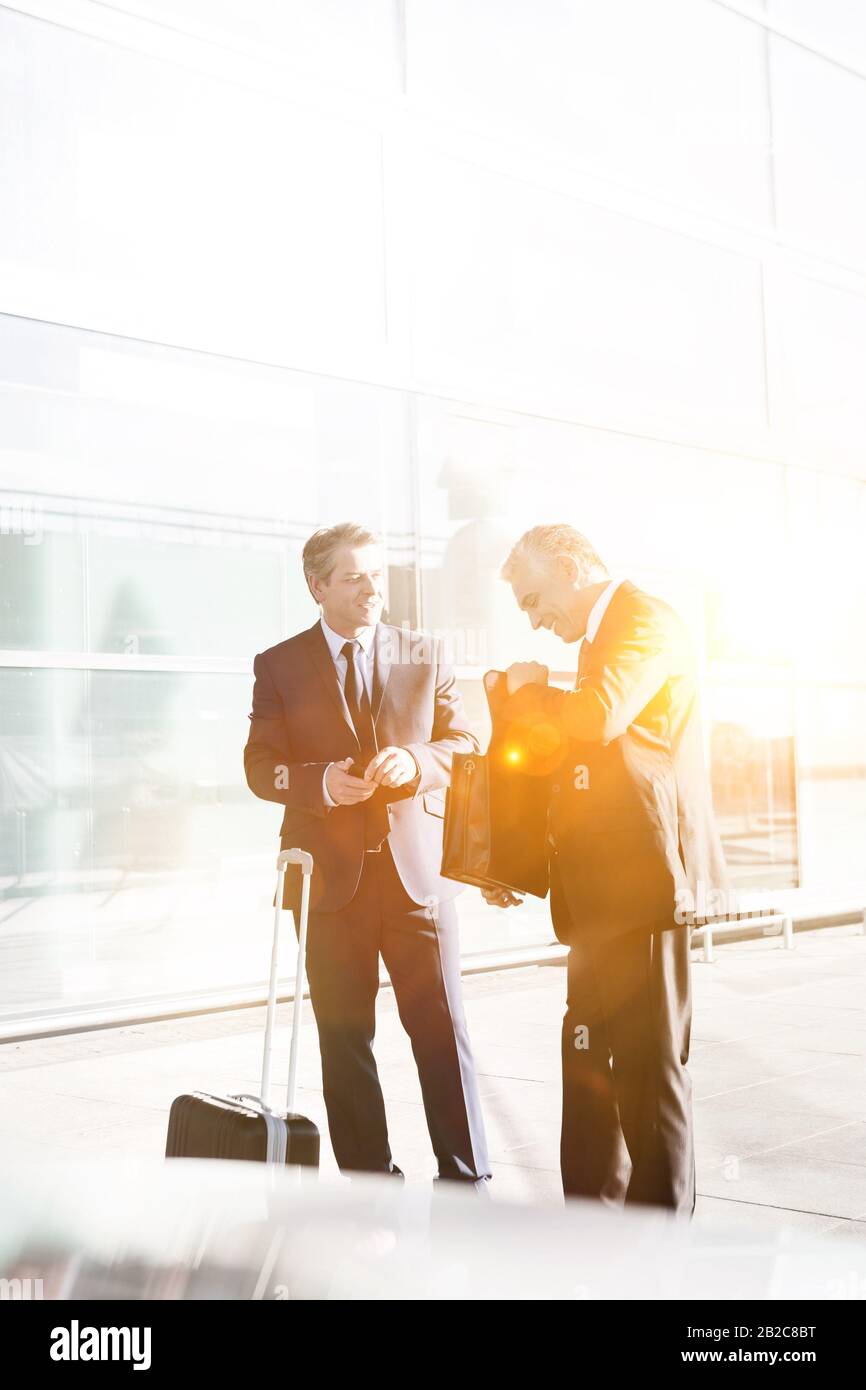 Businessmen standing while talking in the airport Stock Photo - Alamy