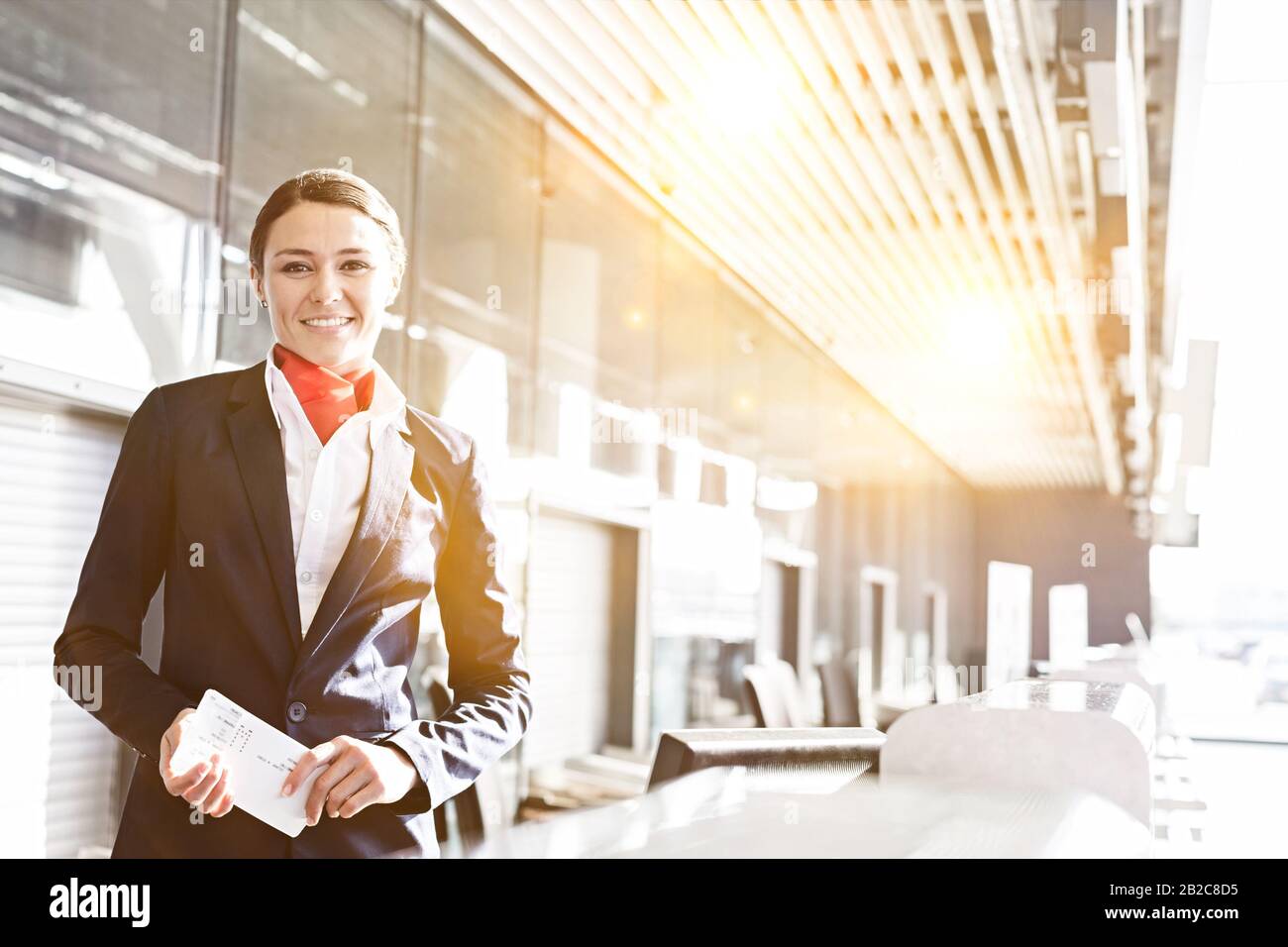 Portrait of young attractive passenger service agent holding boarding ...