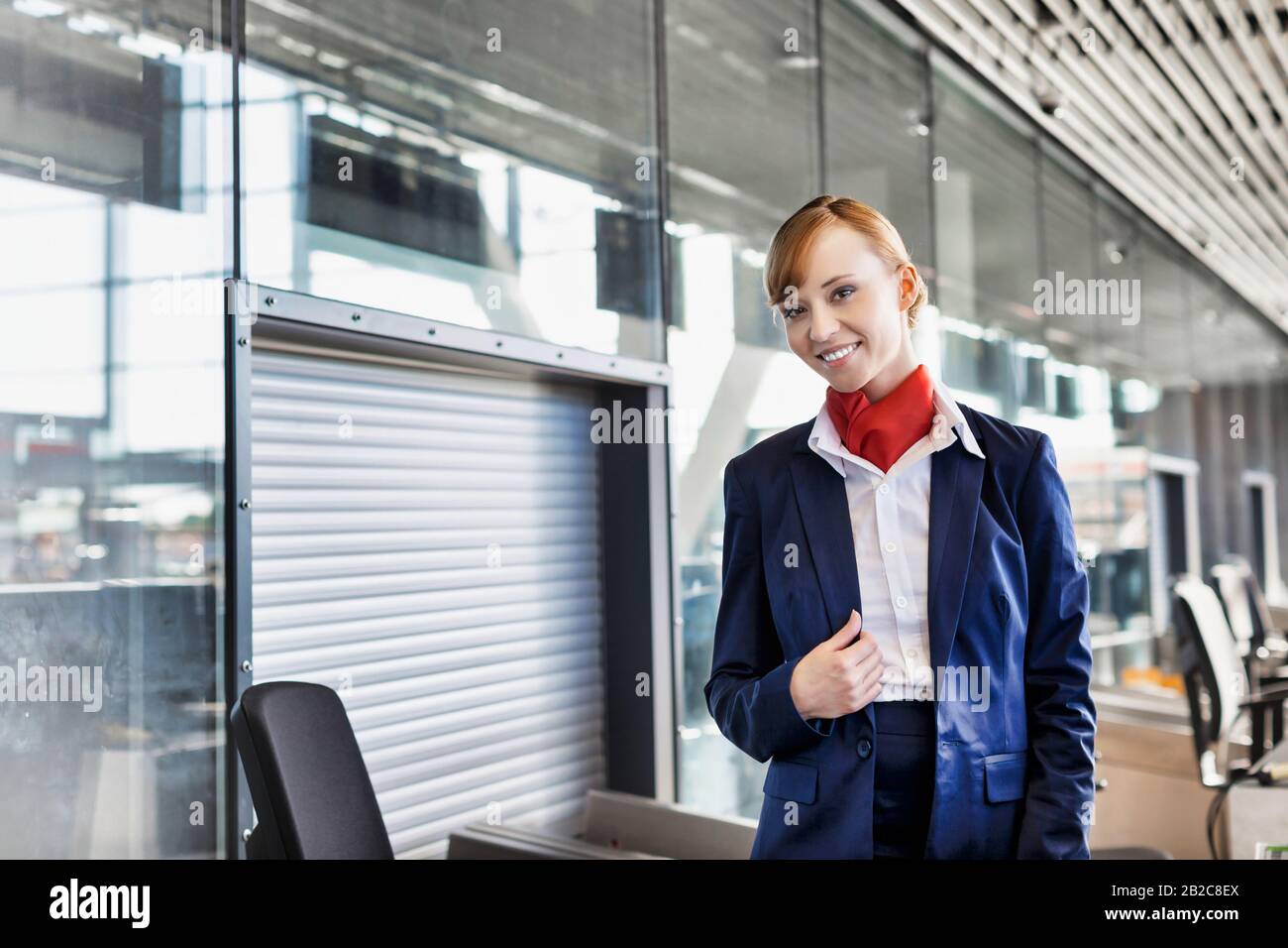 Young attractive airport security personnel standing against x-ray ...