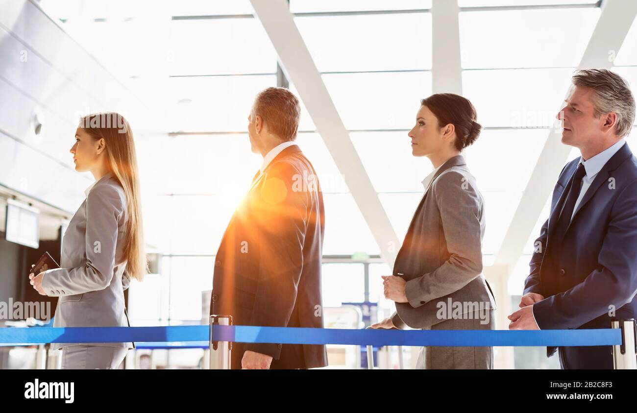 Business people queueing for check in at airport Stock Photo - Alamy