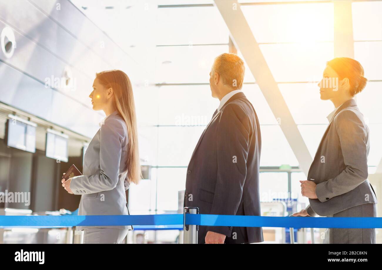 Business people queueing for check in at airport Stock Photo - Alamy