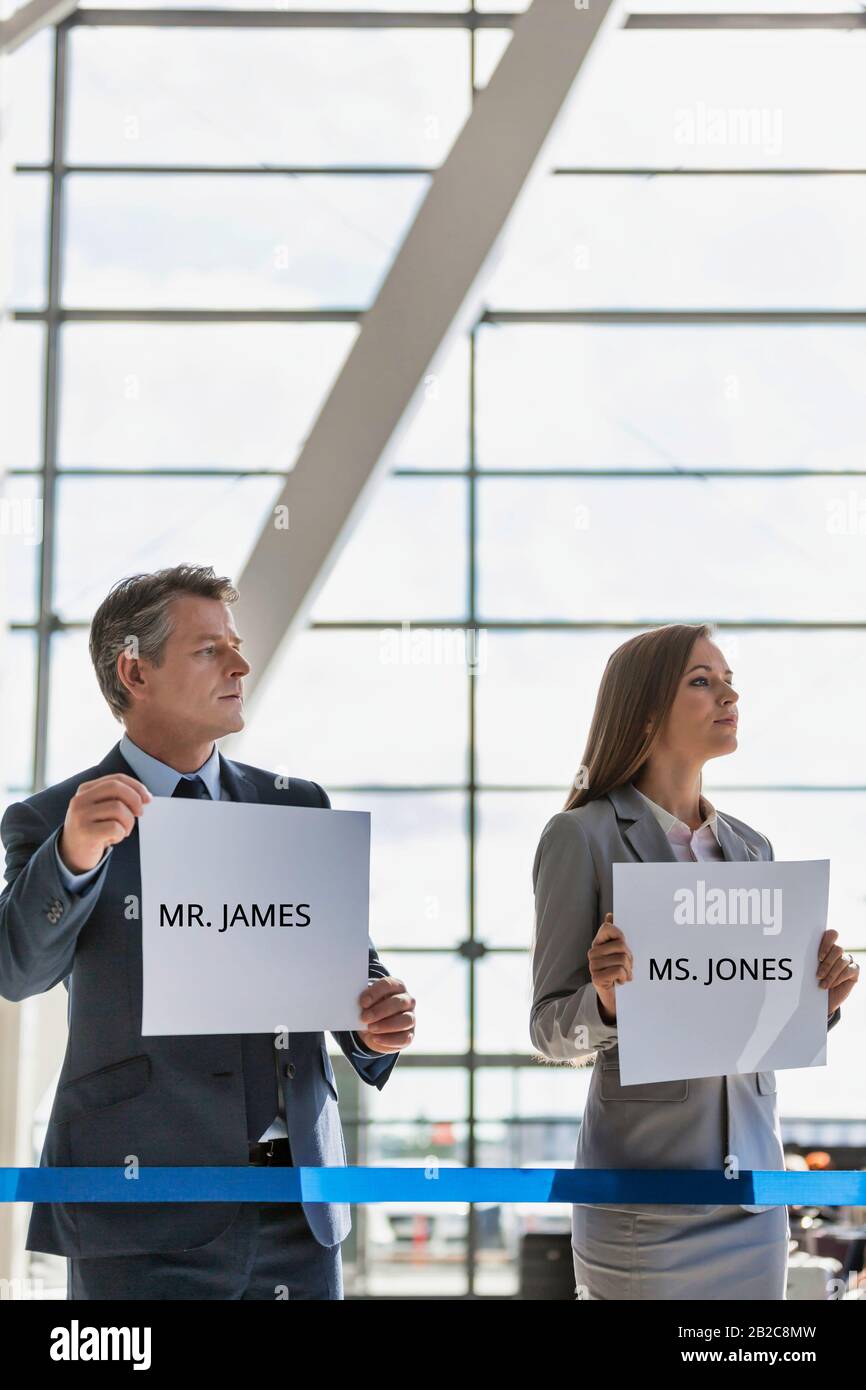 Business people waiting while holding white placard with their boss ...