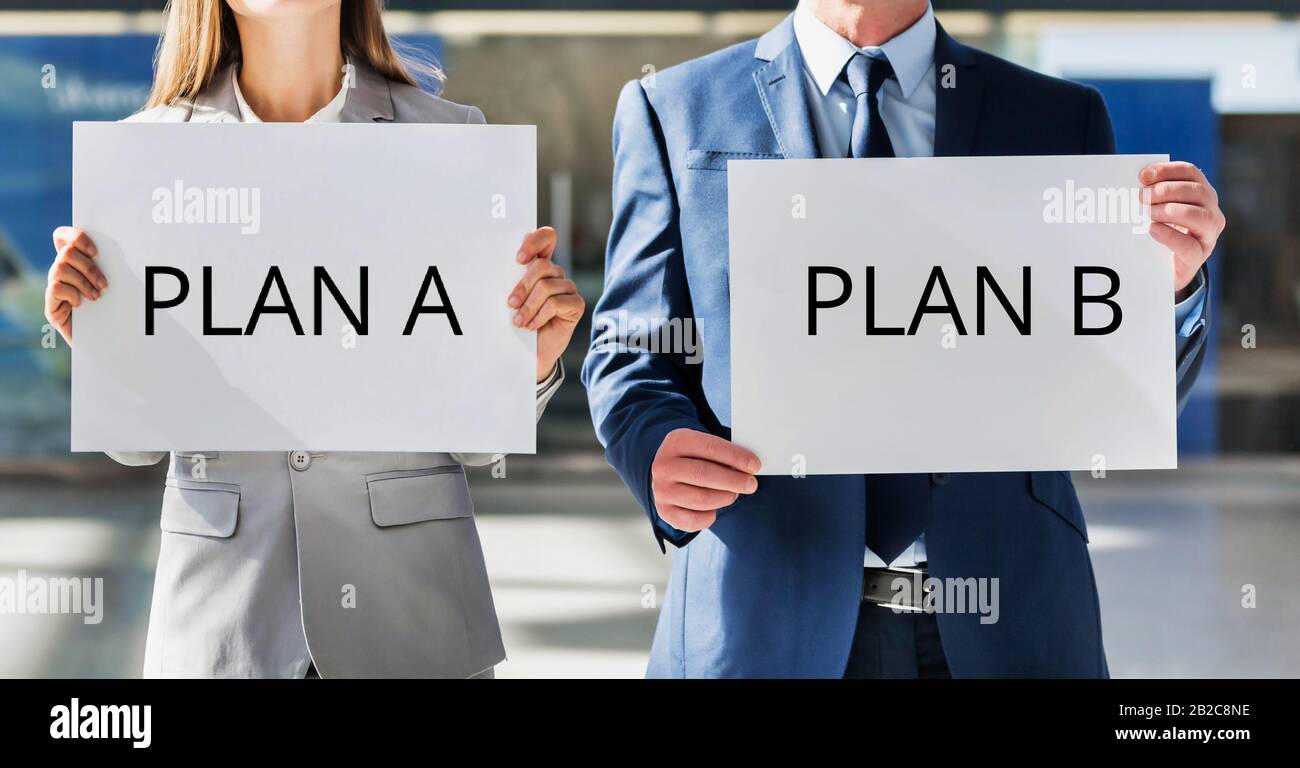Business people standing while holding PLAN A and PLAN B white placard ...