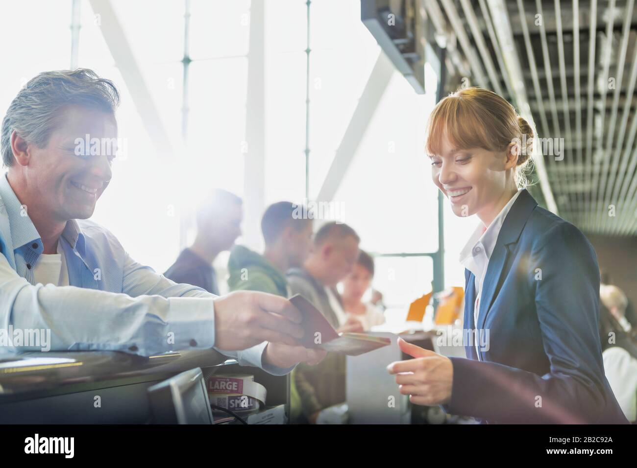 Portrait of man giving his passport for check in with passenger service ...