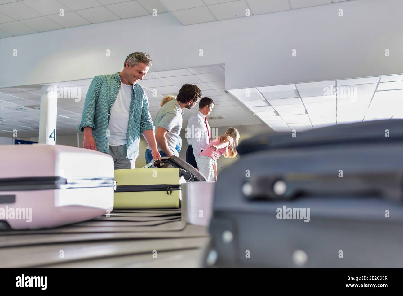 Man getting his suitcase on baggage claiming area in airport Stock ...