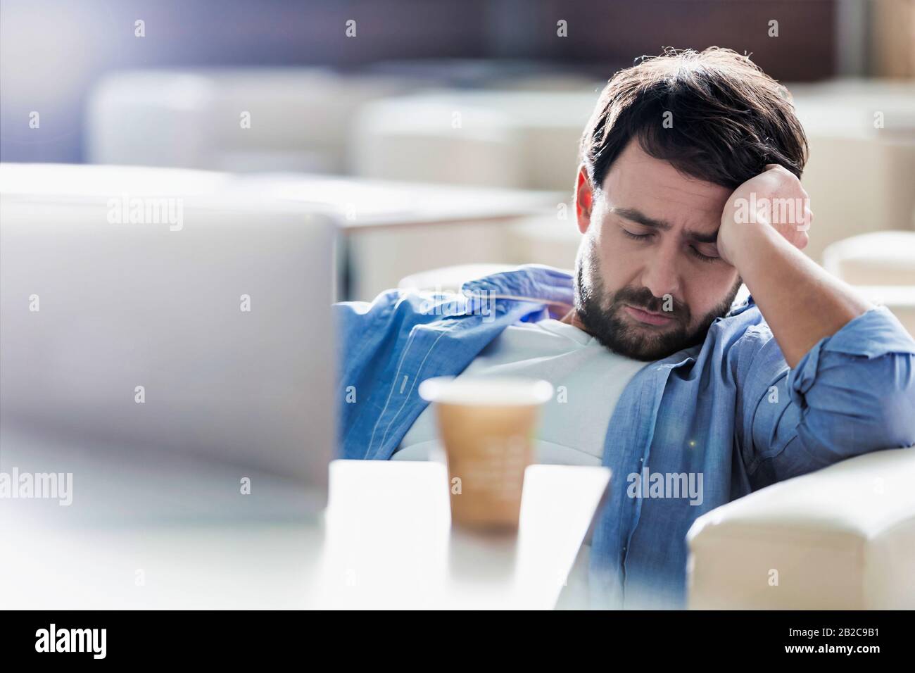 Man taking a nap while sitting and waiting for his flight in cafe at ...