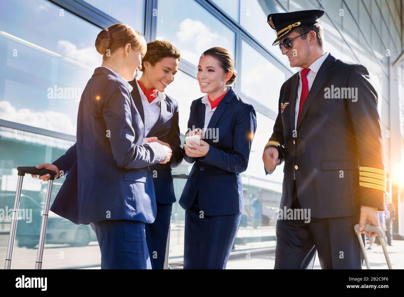 Portrait of mature pilot talking with young attractive flight ...