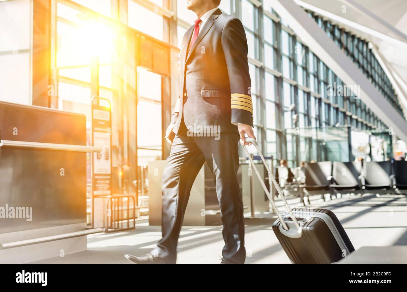Mature pilot walking to enter the plane in boarding gate at airport ...
