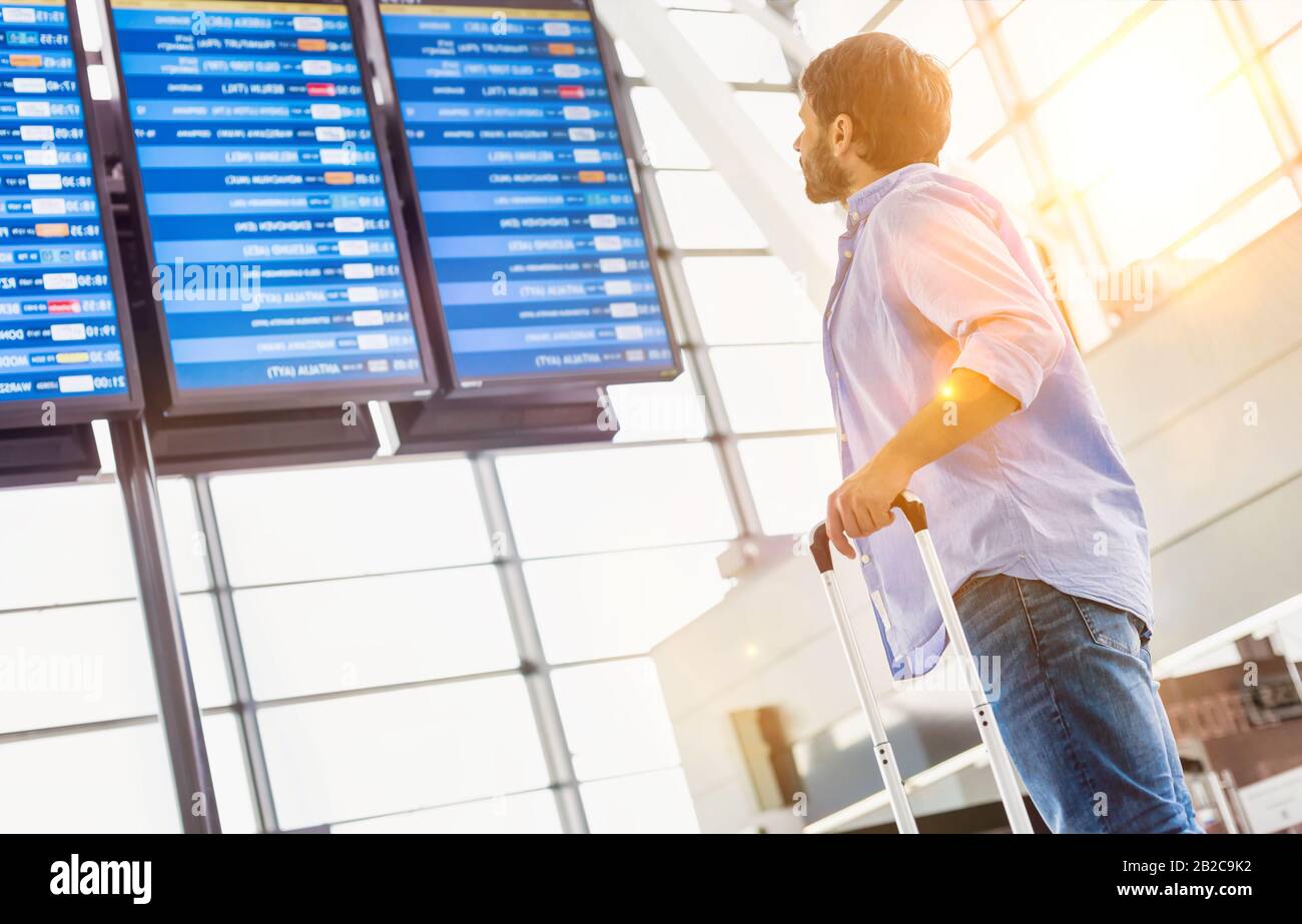 Low angle view of man looking at his flight on screen in airport Stock ...