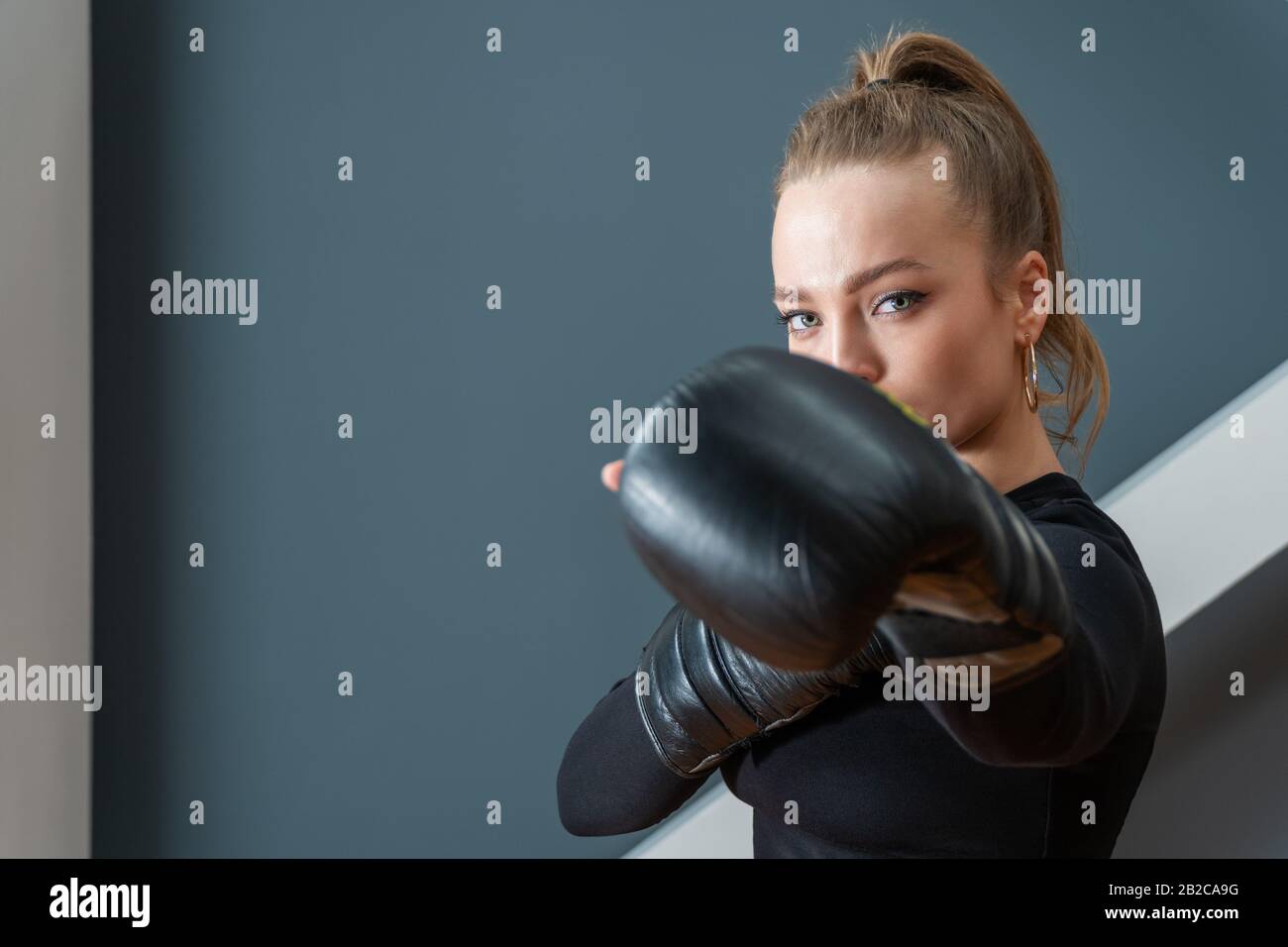 portrait of a beautiful athletic woman in boxing gloves in a protective ...