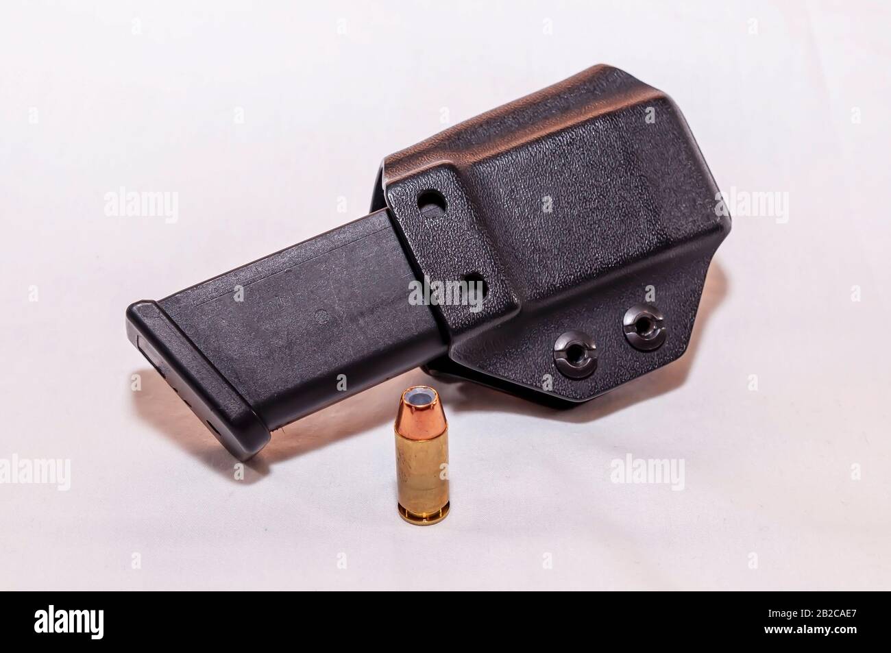 A plastic pistol magazine holder with a pistol magazine in it with a ...