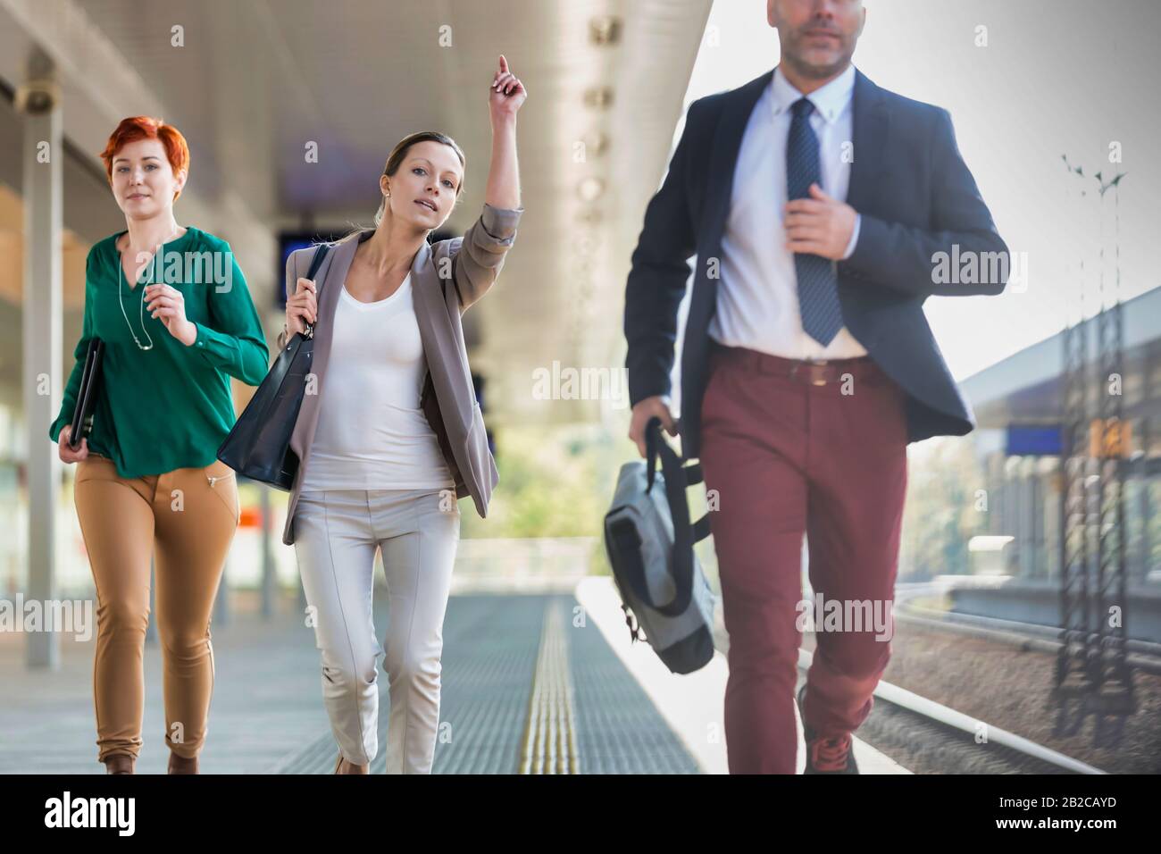 Portrait of business people running to catch the train in station Stock ...