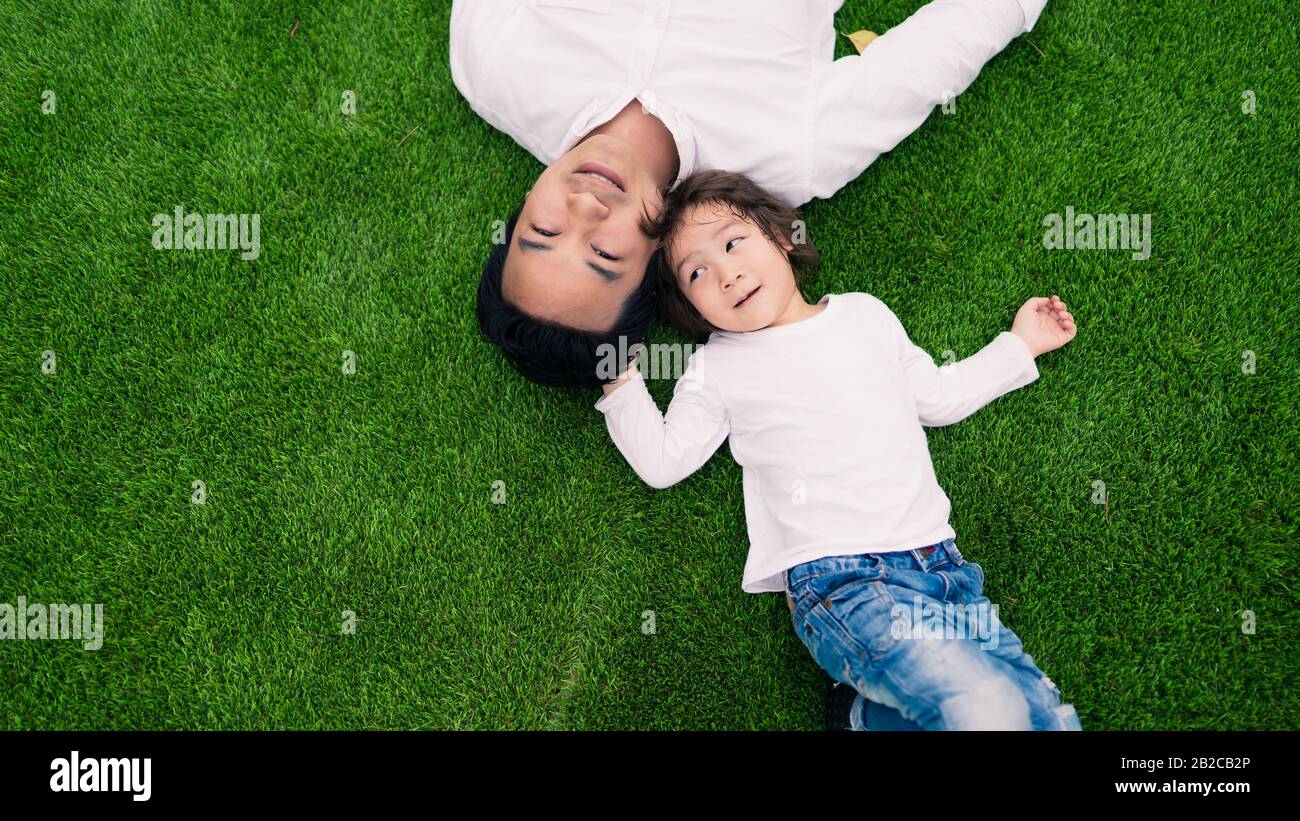 Flat lay of Happy Asian father smiling up to the camera and curious ...