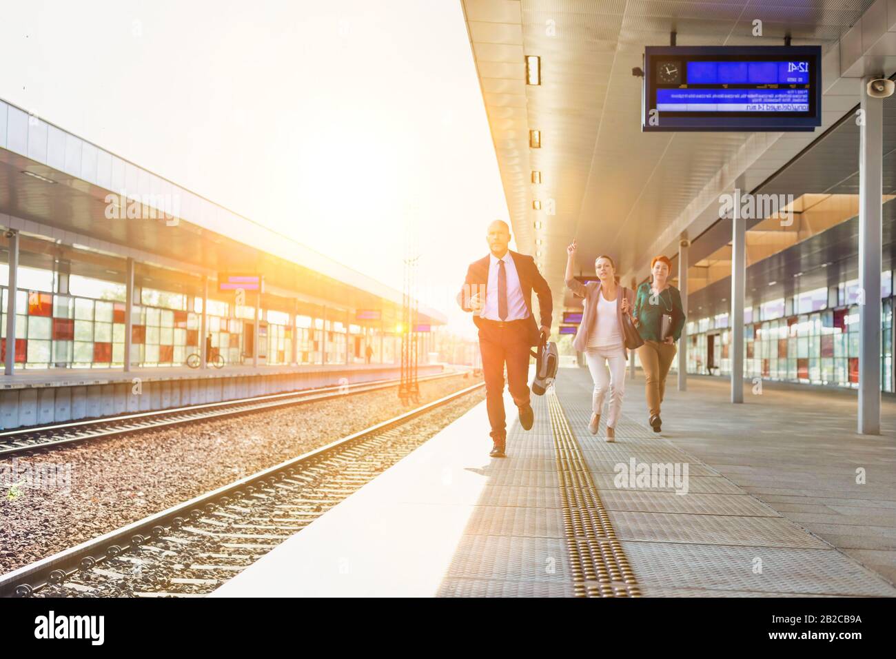 Portrait of business people running to catch the train in station Stock ...