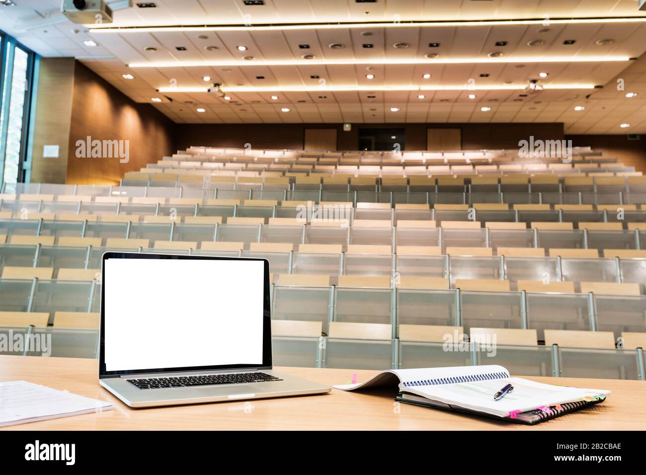 Photo of laptop on professor desk with tumbler in classroom Stock Photo ...