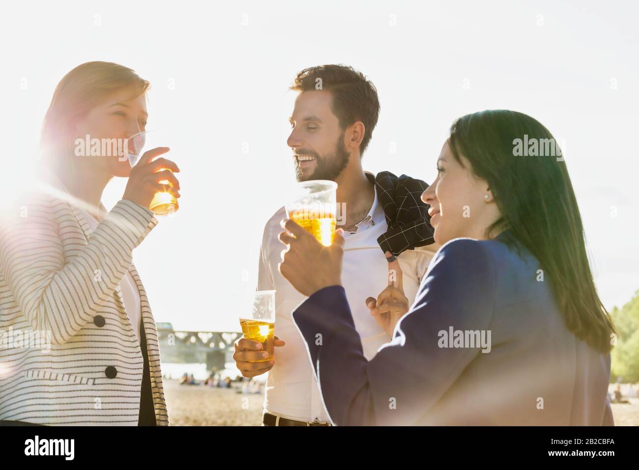 Business people celebrating success while drinking beer on the beach ...