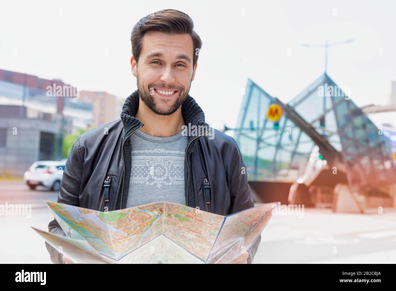 Portrait of young attractive man looking on the map in the city Stock ...