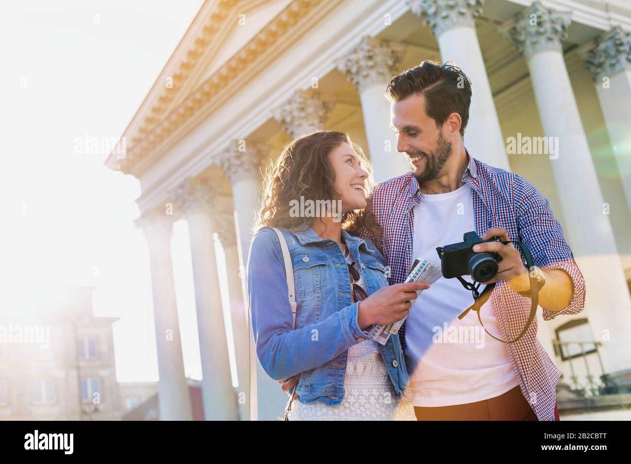 Portrait of handsome young man showing pictures on camera to his ...