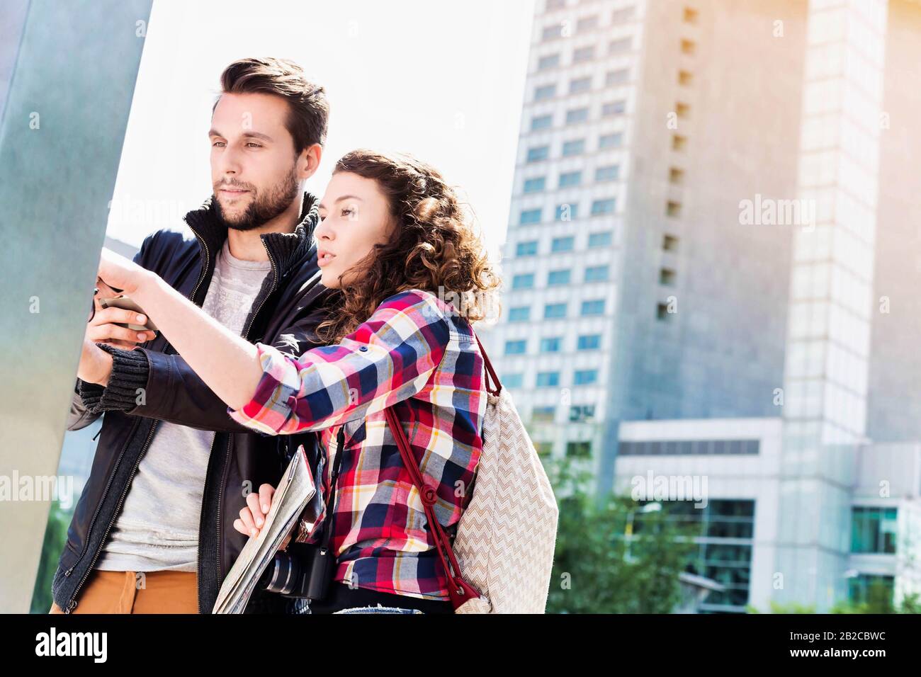 Portrait of young attractive couple looking at the monitor with lens ...