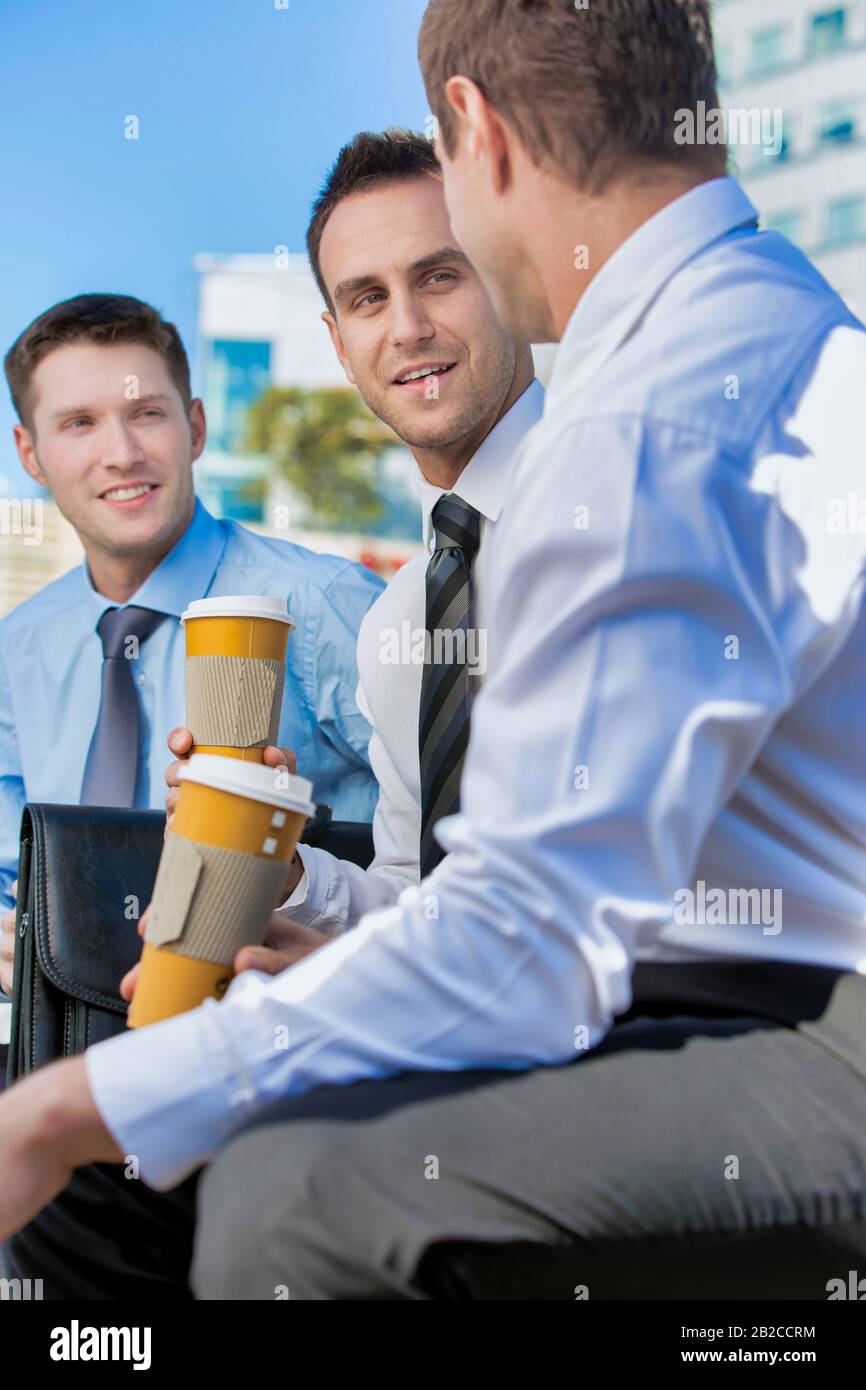 Group of colleagues sitting and talking while drinking coffee after ...