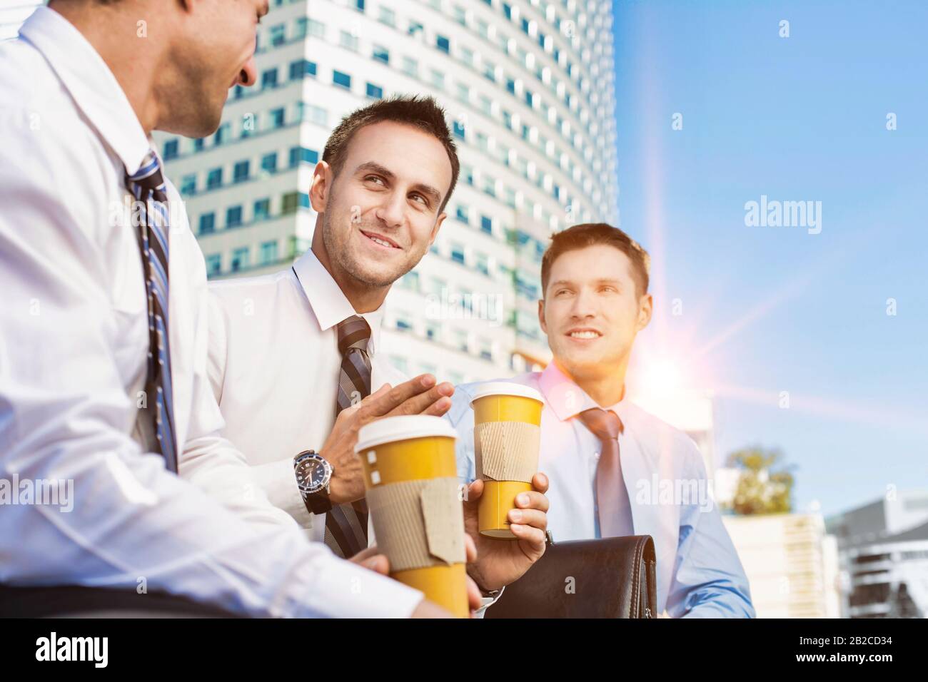 Group of colleagues sitting and talking while drinking coffee after ...