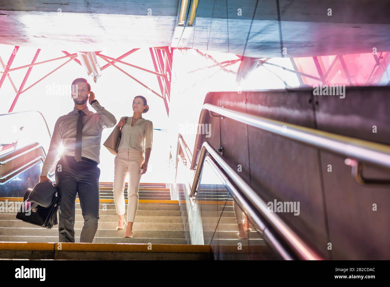 Business people walking downstairs with lens flare in background Stock ...