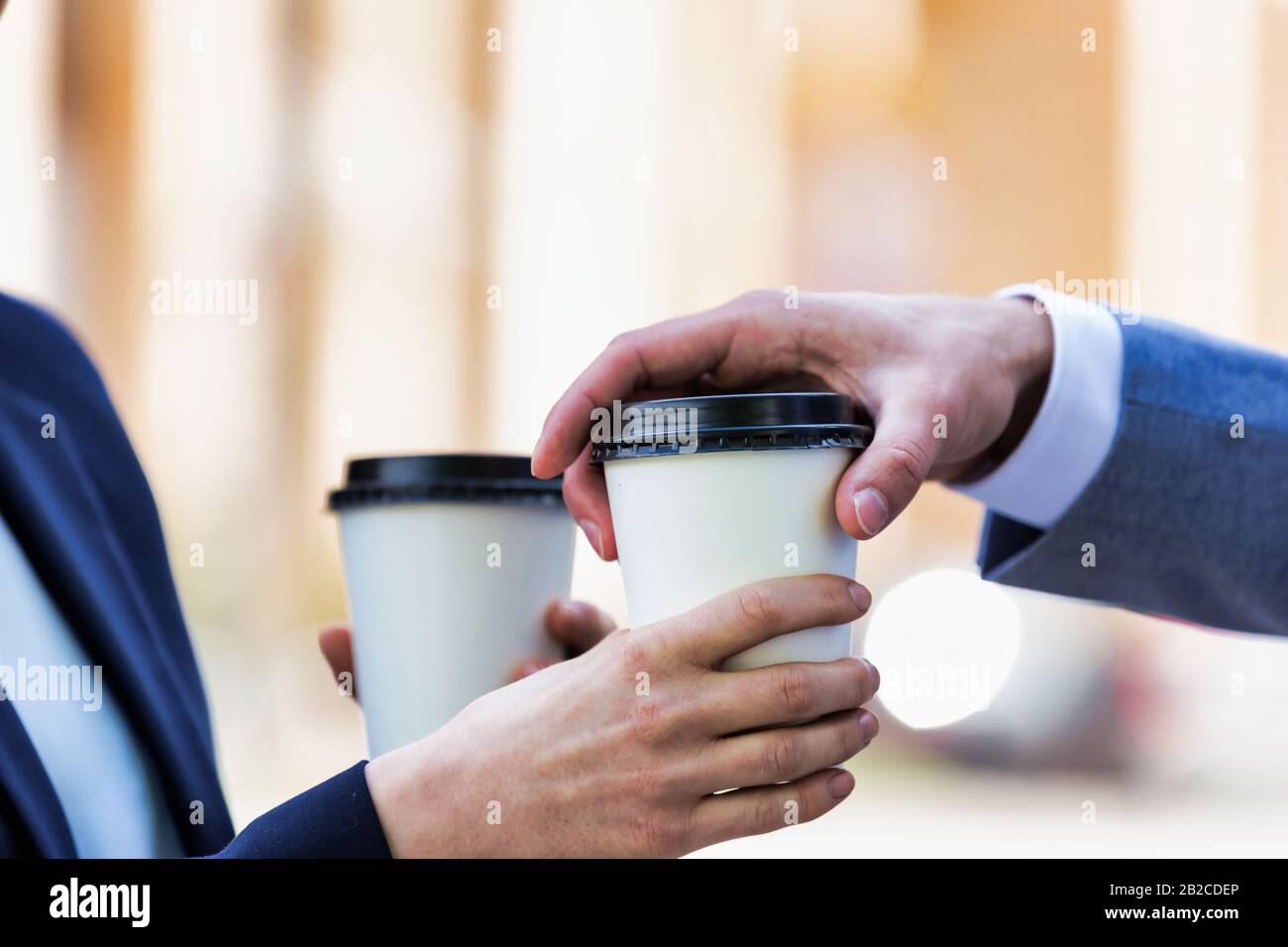 Close up photo of businesswoman giving businessman a cup of coffee ...
