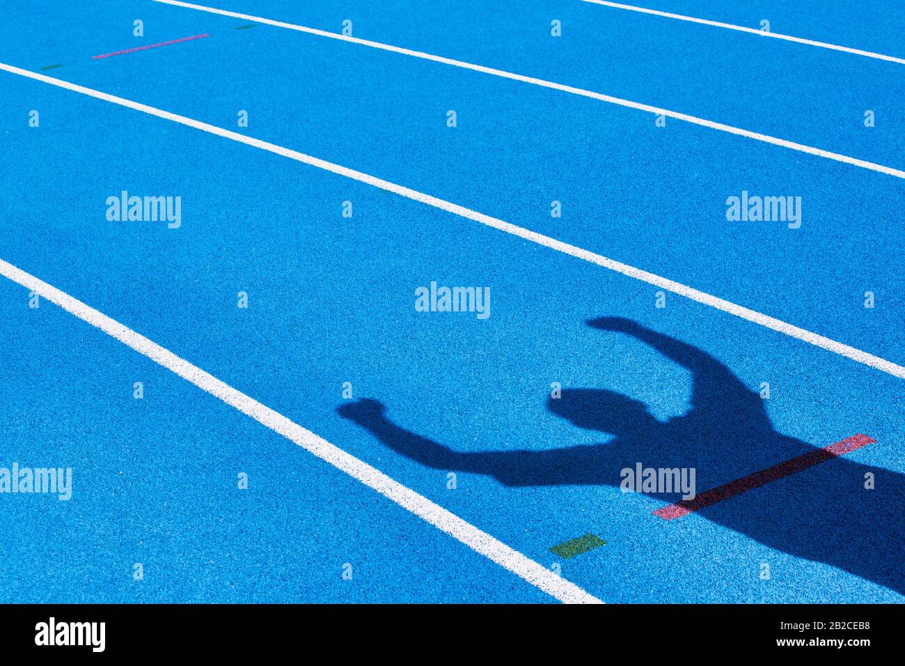 Shadow of an athlete celebrating success in finish line Stock Photo - Alamy