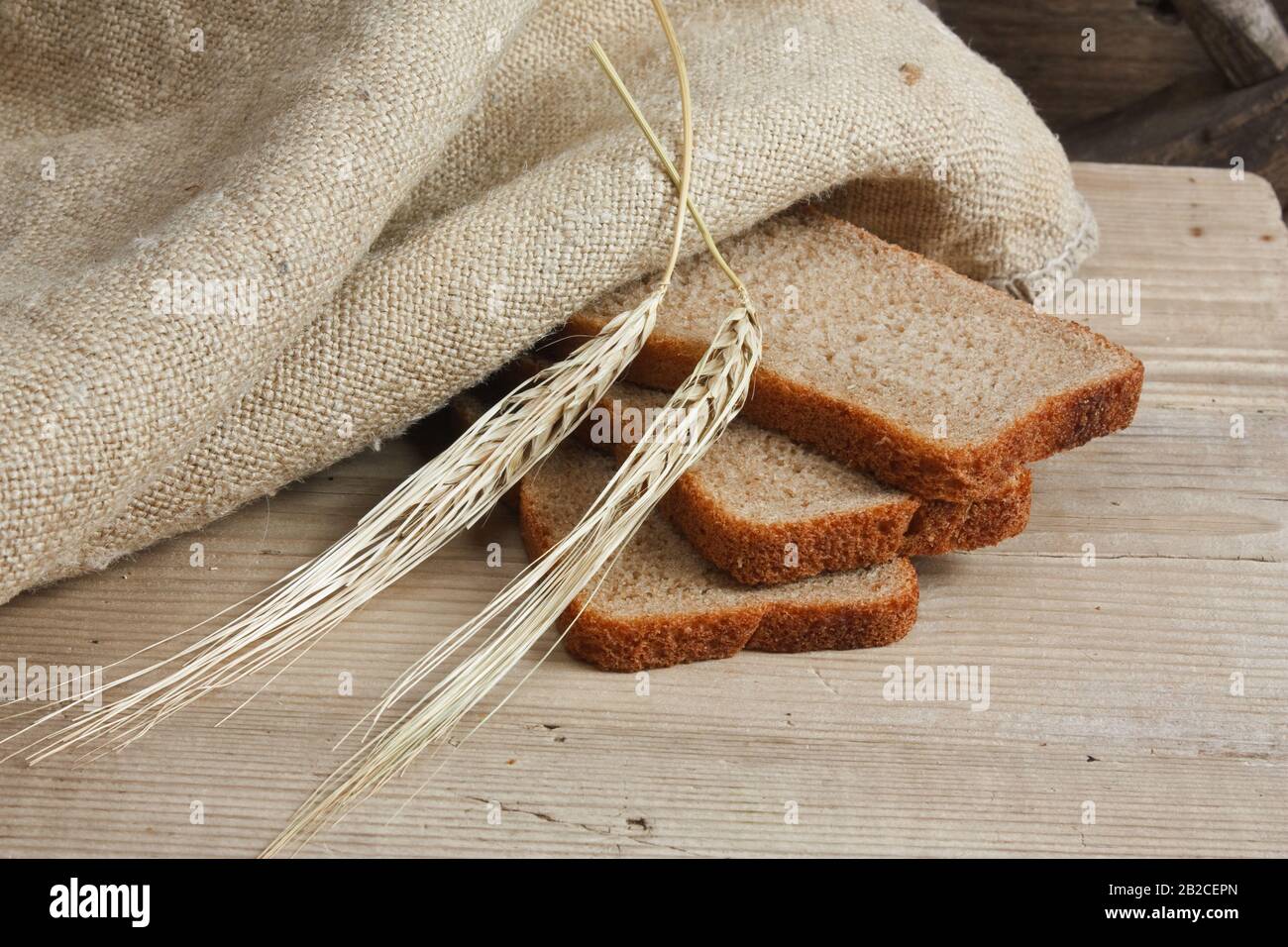 slices of rye bread and ears of corn on the wooden table Stock Photo ...
