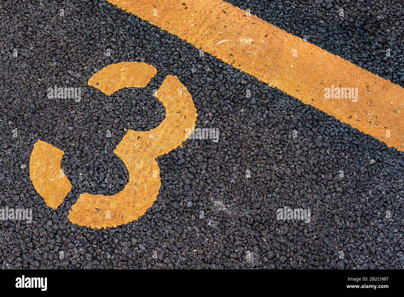 Asphalt parking lot with yellow lot line and yellow lot number 3 Stock ...