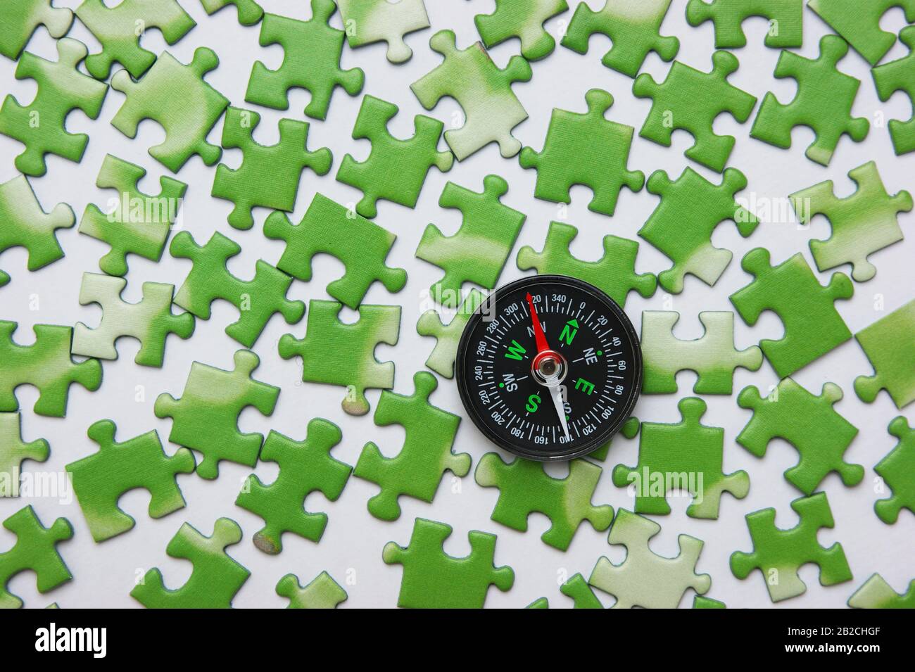 compass on the green puzzle Stock Photo - Alamy