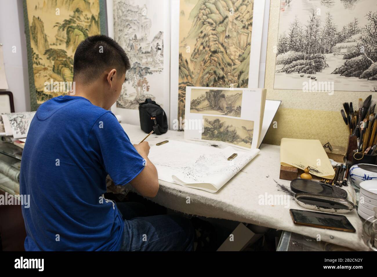 BEIJING, СHINA - JUNE 01, 2019: Young Chinese artist at his work place ...