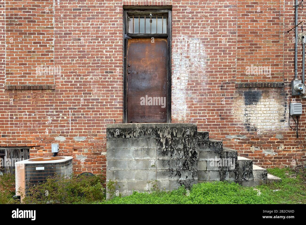 a beautiful old rusted warehouse door on a vintage red brick building ...