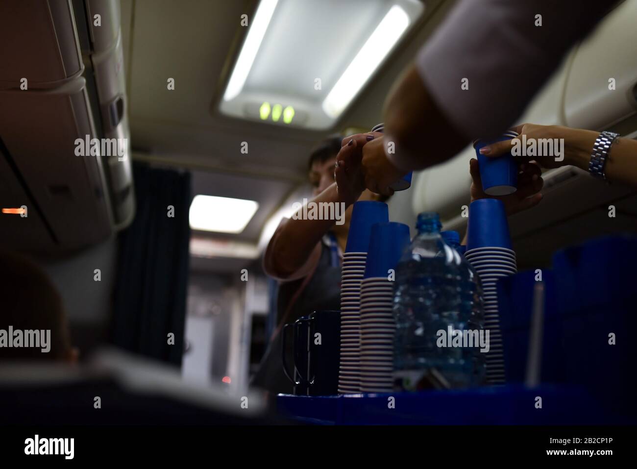 Stewardess on a plane gives drinking water to a passenger Stock Photo ...