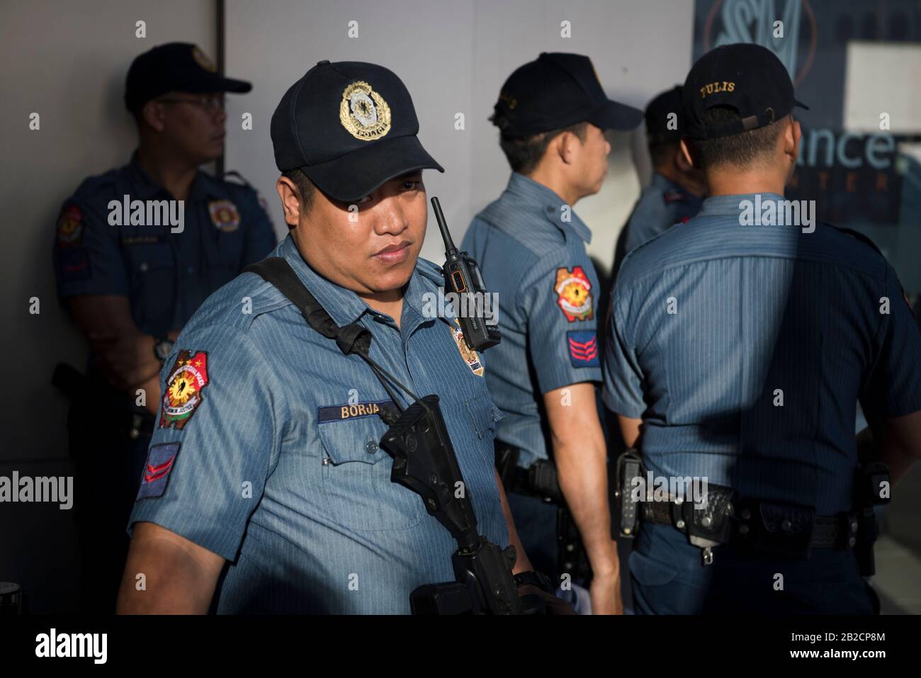 Police officers stand alert outside V shopping Mall in Manila.Police ...