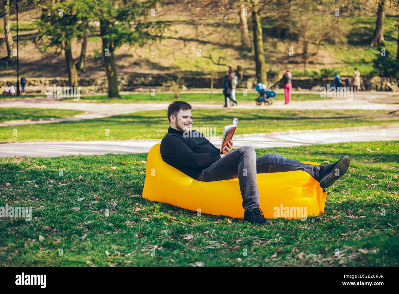 book reading concept. man in city park on inflatable mattress Stock ...