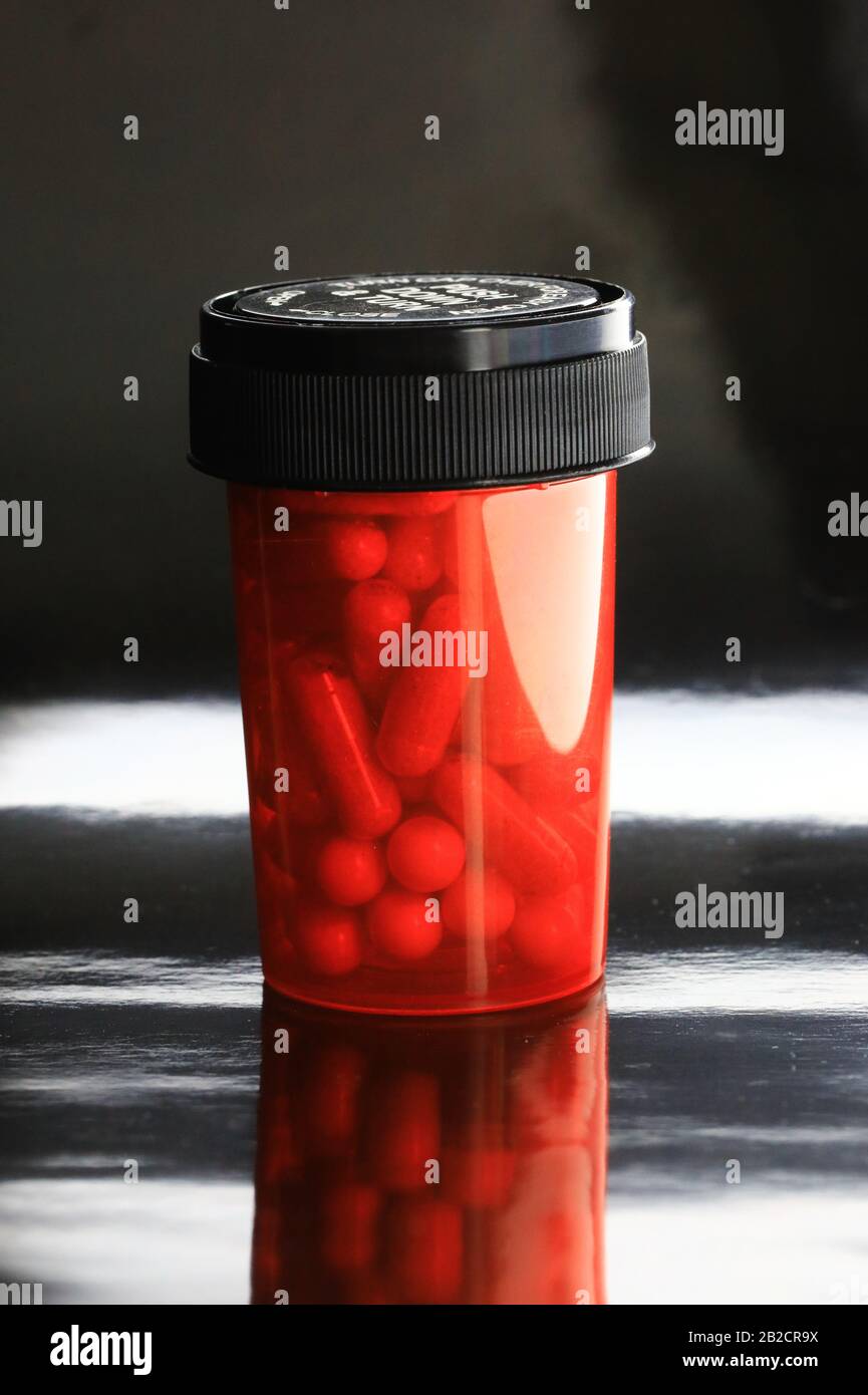 Pharmaceutical meds in a red tinted bottle Stock Photo - Alamy